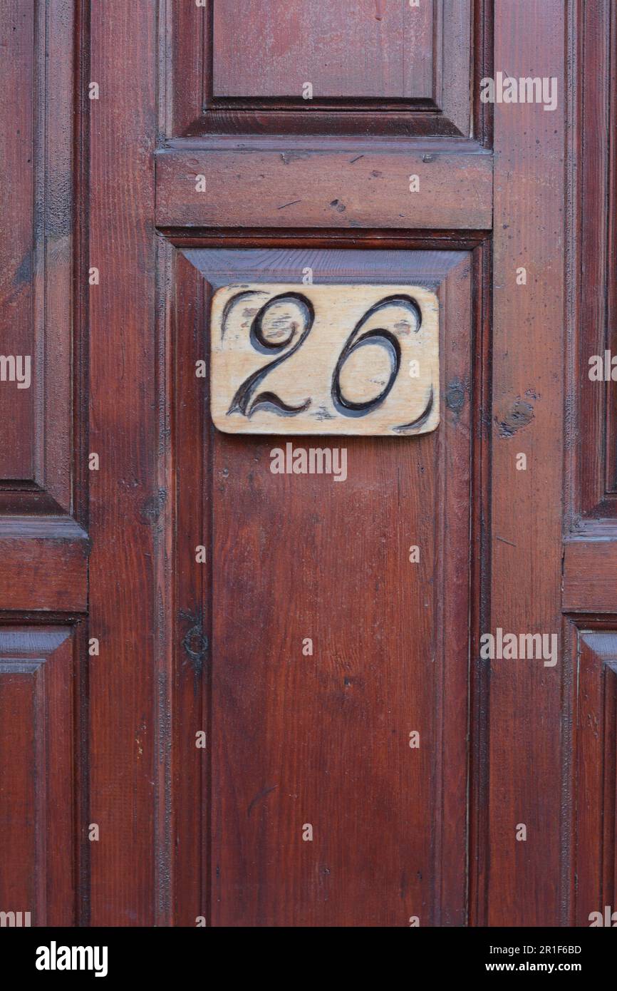 Plate with house number twenty six on wooden door, closeup Stock Photo ...