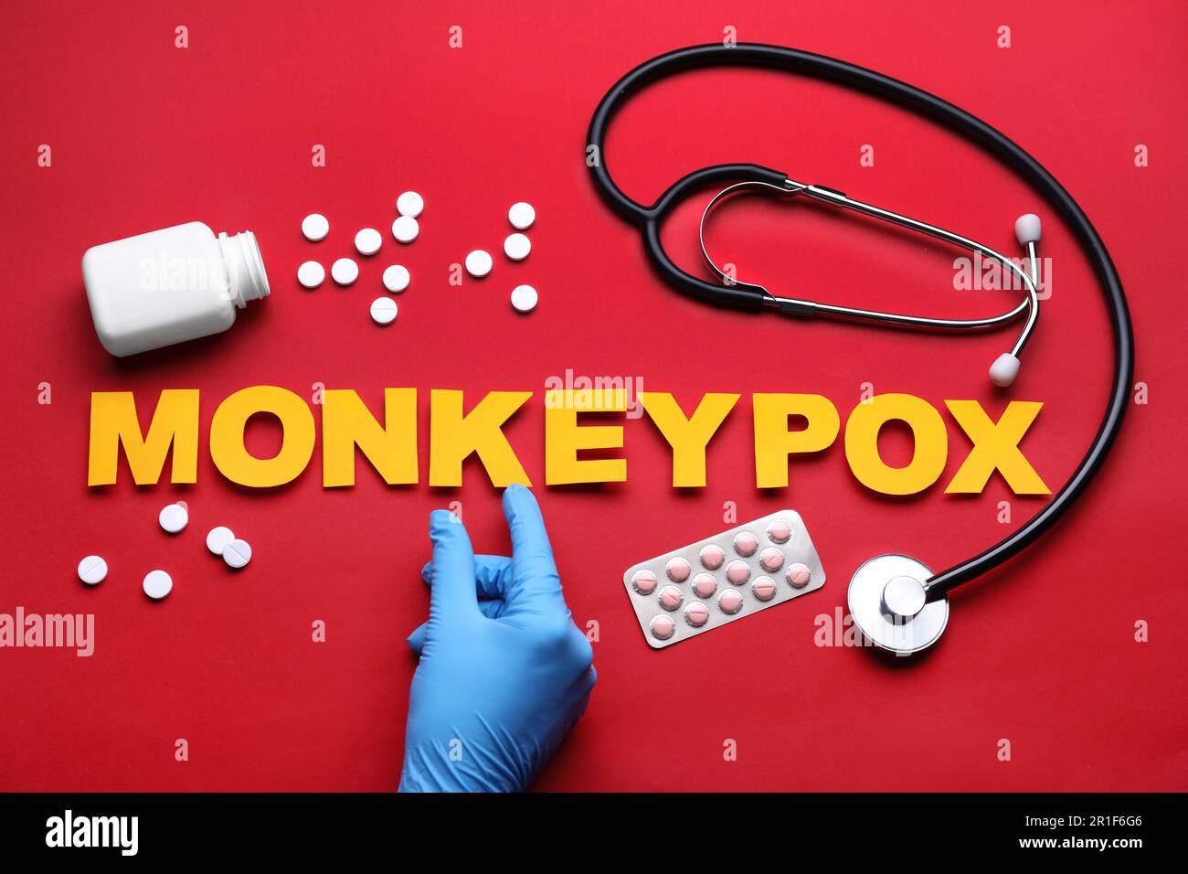 Nurse making word Monkeypox of paper letters, pills and stethoscope on ...