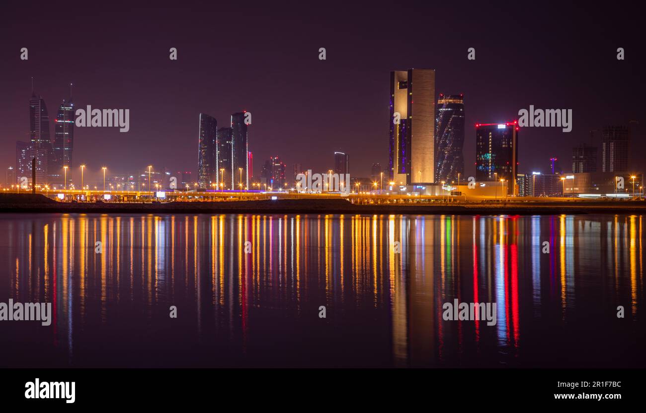 Manama illuminated downtown on the shore reflected in waters of Persian ...