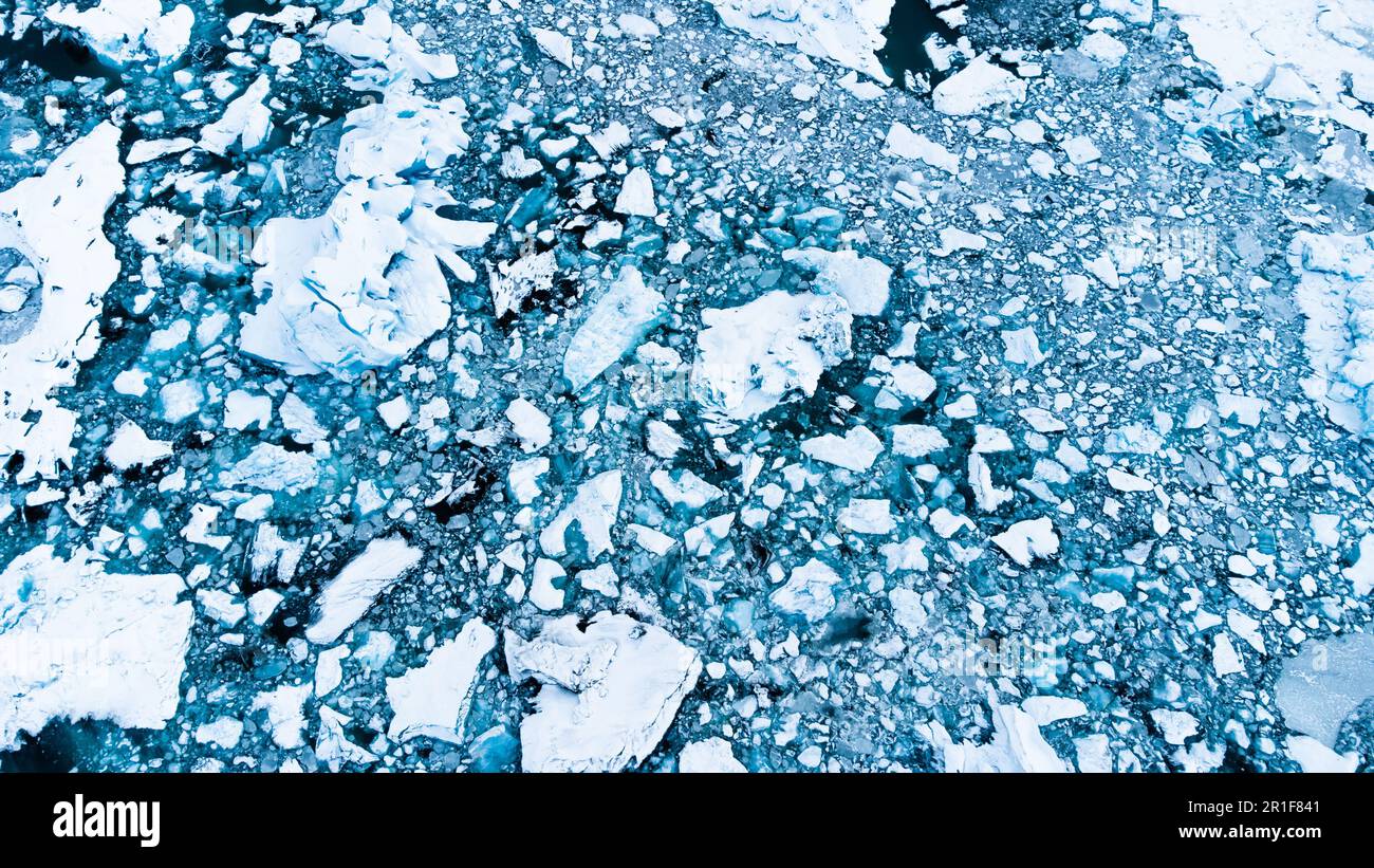 Melting Arctic ice in ocean water. Blue glacier ice covered with snow ...