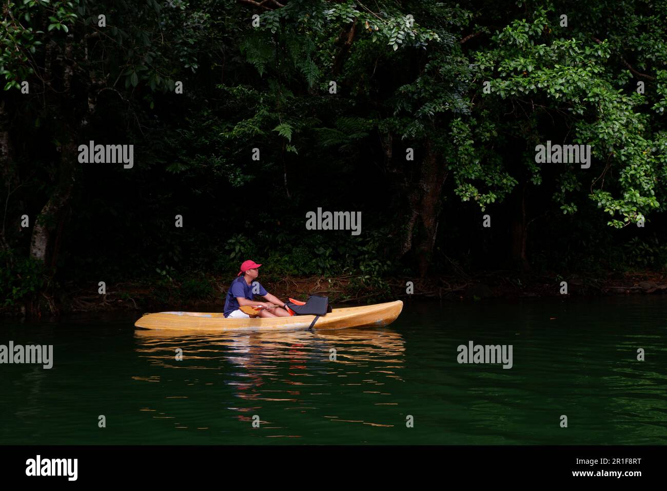 One man kayaking at Bulusan Lake, Philippines with colorful reflection ...