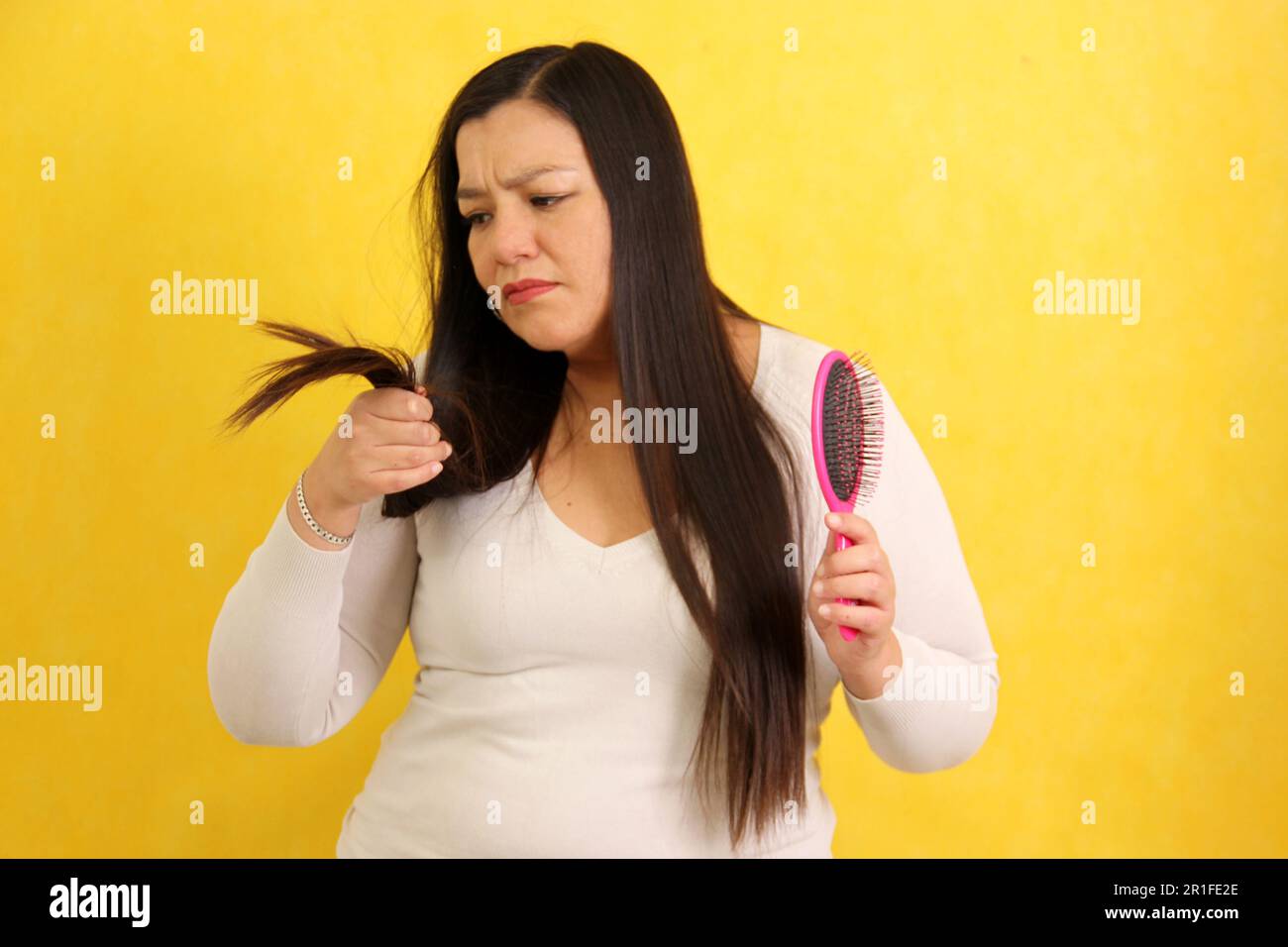 Adult Latina Woman With Very Long Hair Worries And Suffers While Brushing Because Her Hair Falls
