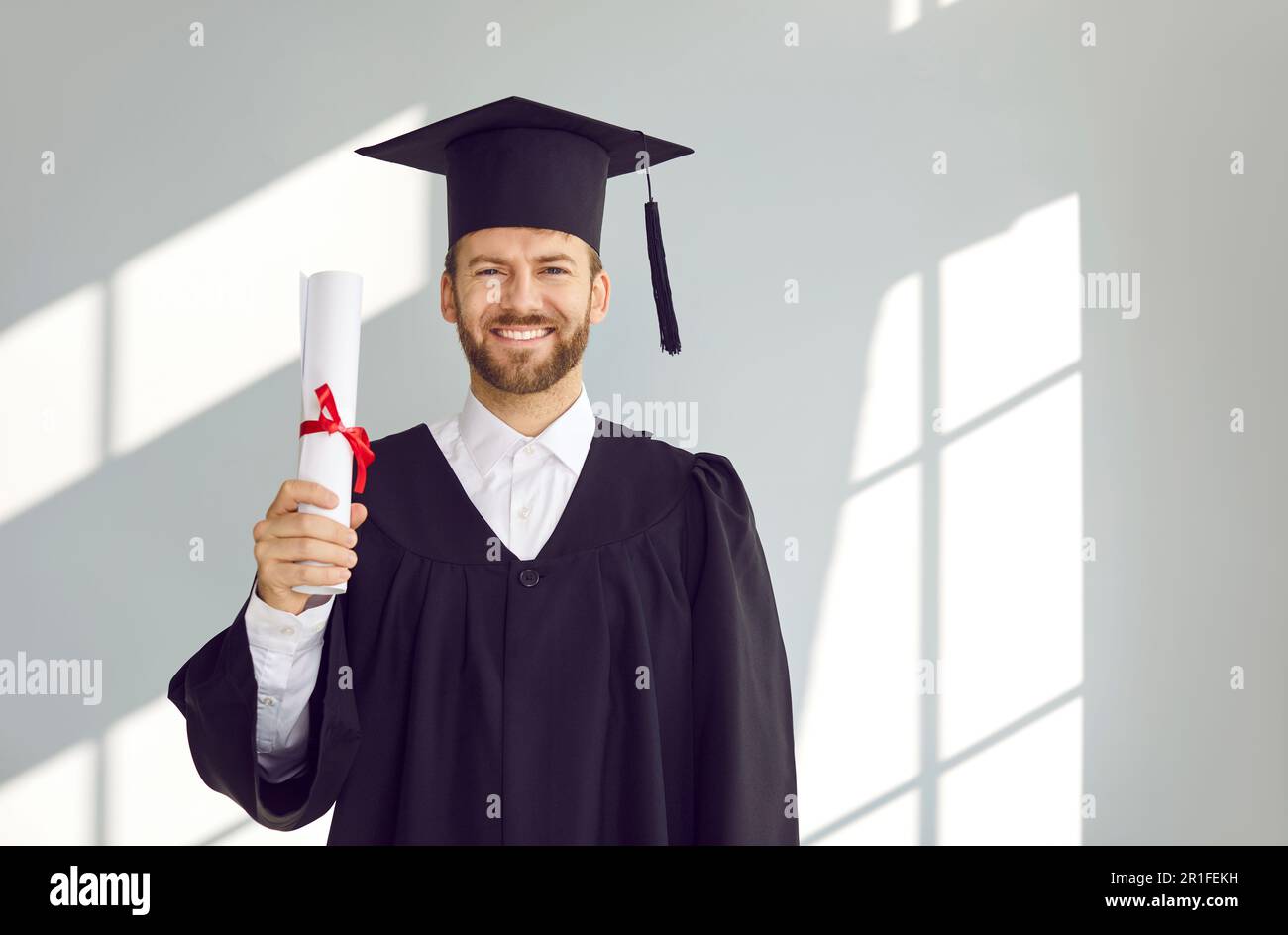 Portrait of happy male graduate student standing with diploma Stock ...