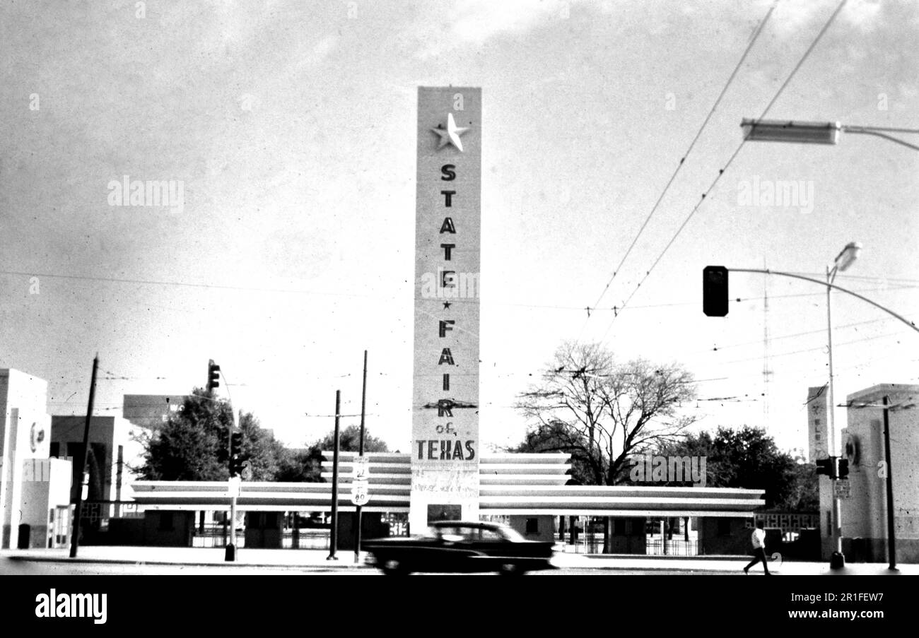 Black and white photogrpah of a car driving by State Fair of Texas sign ...