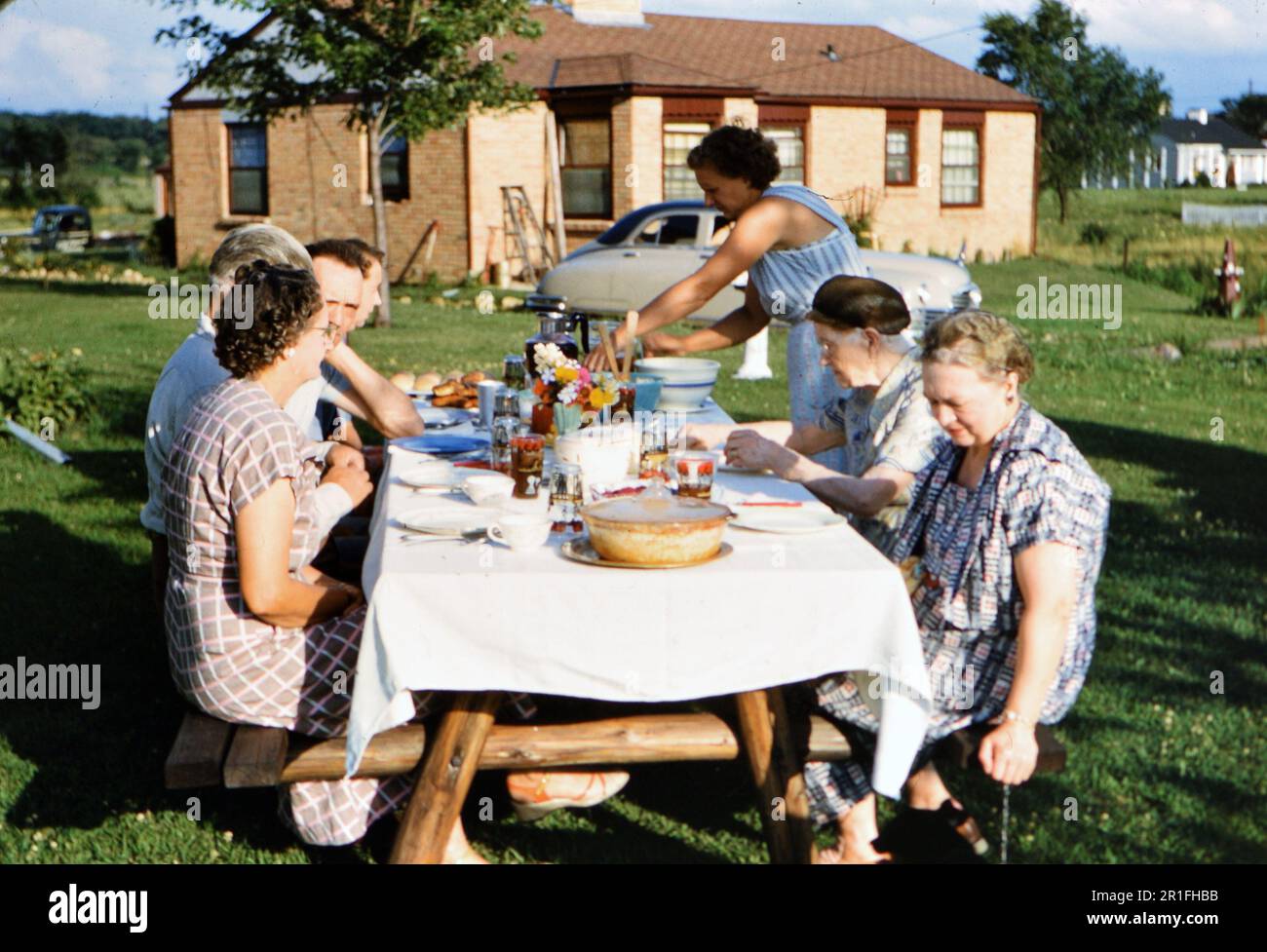Older Men And Women Eating Outside Their Home On A Picnic Table Ca 1950s Stock Photo Alamy