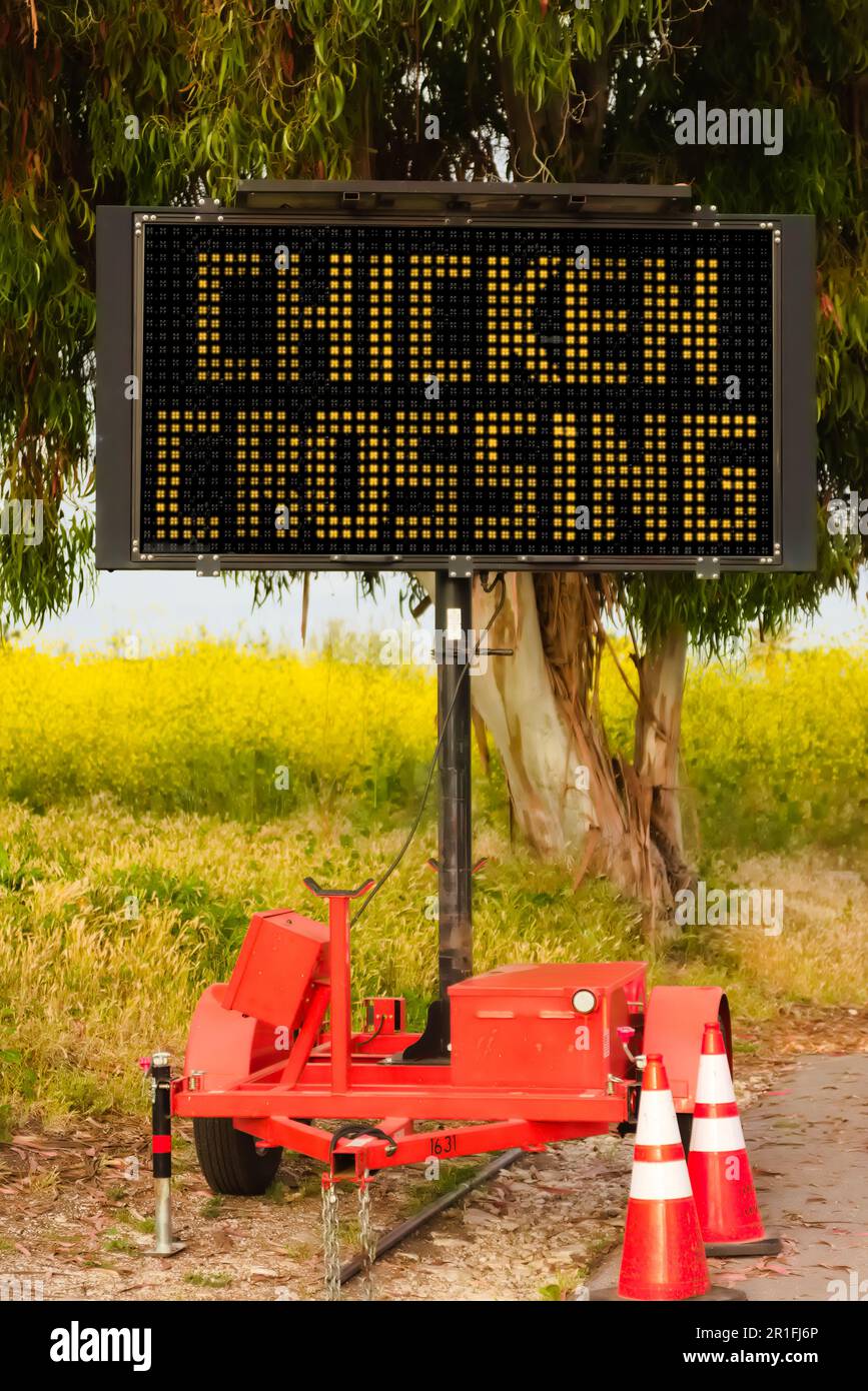 An electronic road sign displays a humorous message -- CHICKEN CROSSING ...