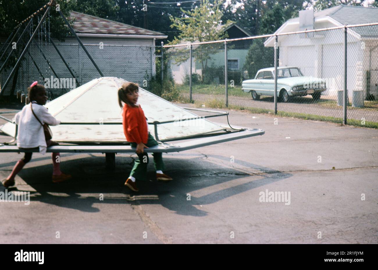 kids playing in playground on a vintage merry-go-round ca. 1977 Stock ...
