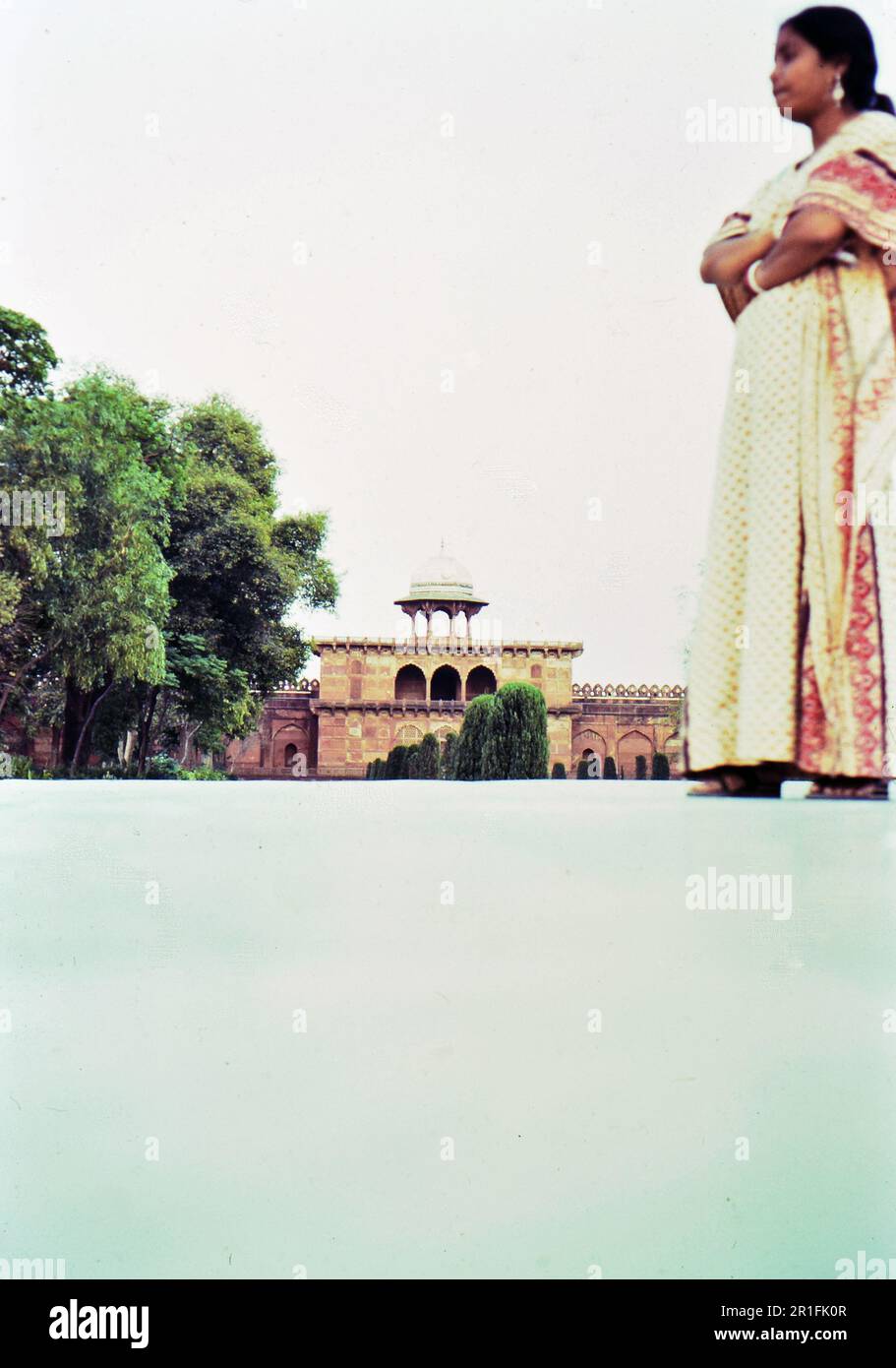 Indian woman in India, standing in front of a building, looking left ca ...