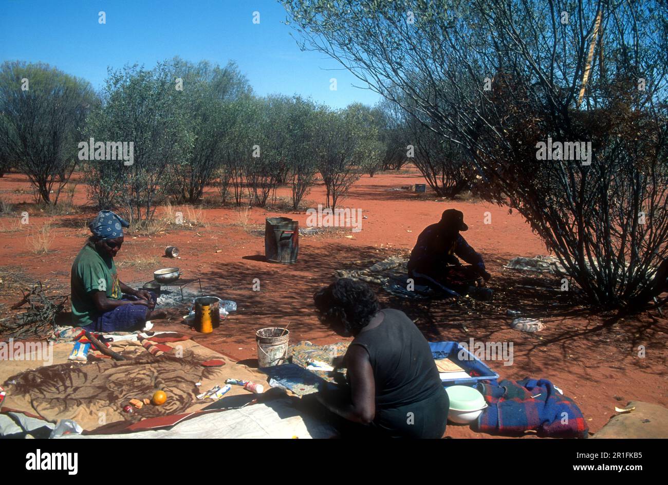 Aboriginal artists painting in a bush camp in the Northern Territory of ...