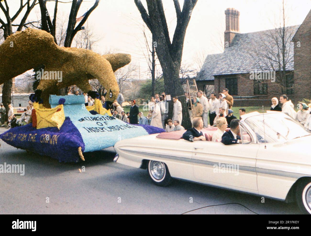 Crowd on a cold day watch as a patriotic float with an eagle the words ...