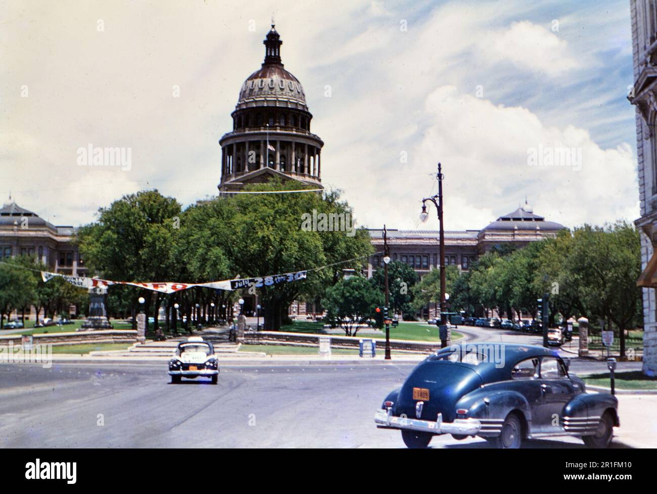 Car on the road and one parked car in front of the Texas state capitol ...