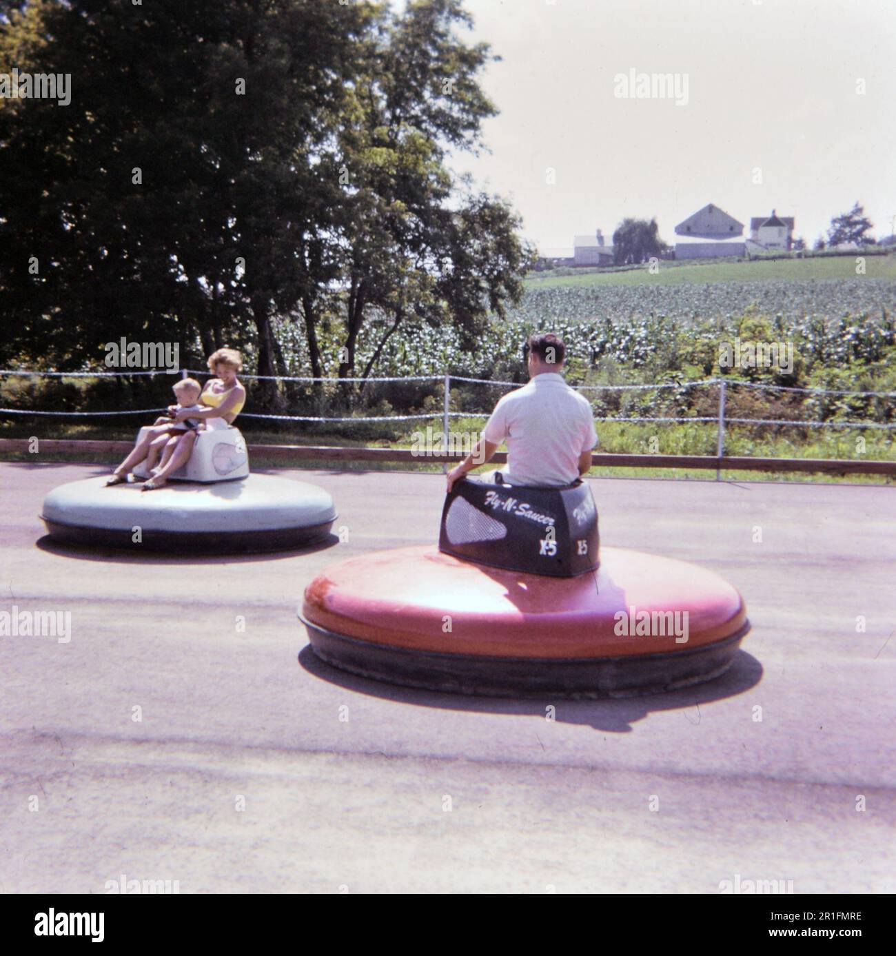 A mother, father and child enjoying riding a fly-n-saucer X-5 ride at ...