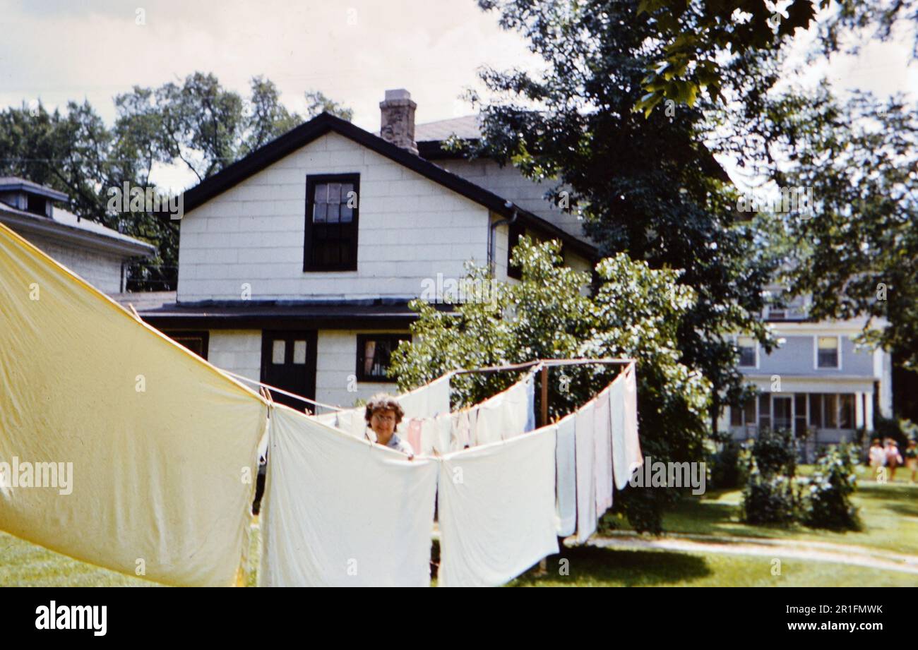 Woman hanging out laundry on a clothes line ca. 1962 Stock Photo - Alamy