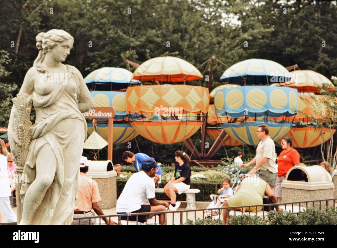 Visitors at an unidentified American amusement park taking a rest in a ...