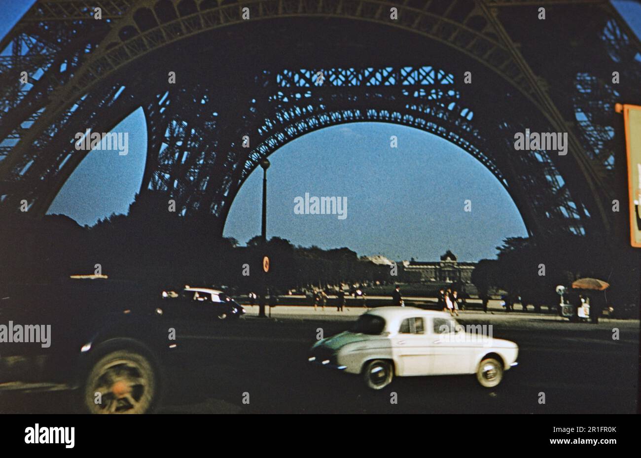Cars driving past the Eiffel Tower in Paris France ca. approx. mid ...