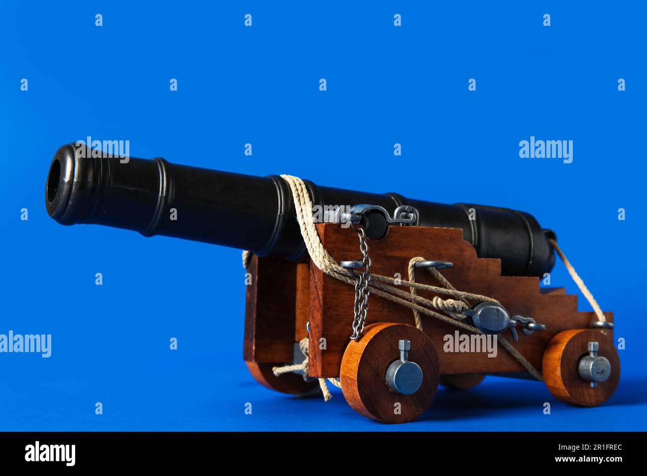 Toy model of cannon on blue background Stock Photo - Alamy