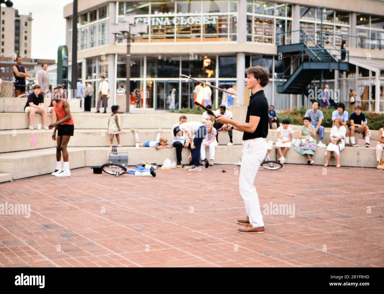 A performer juggling fire in front of a crowd at Harborplace in ...