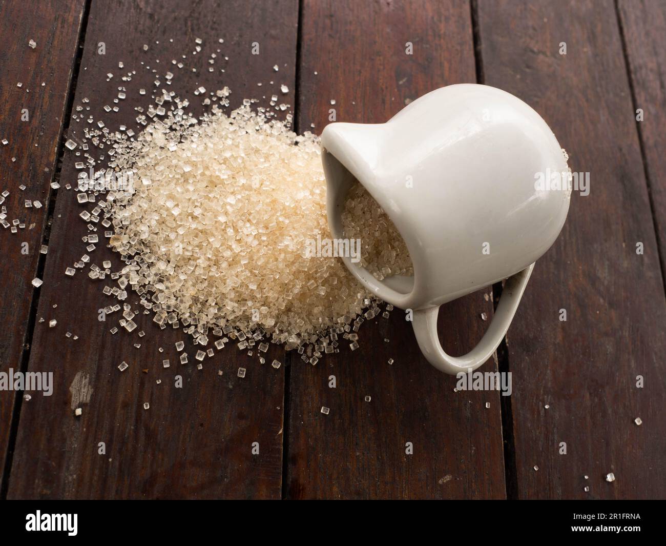 Picture of sugar that spilled from a white ceramic container on a ...