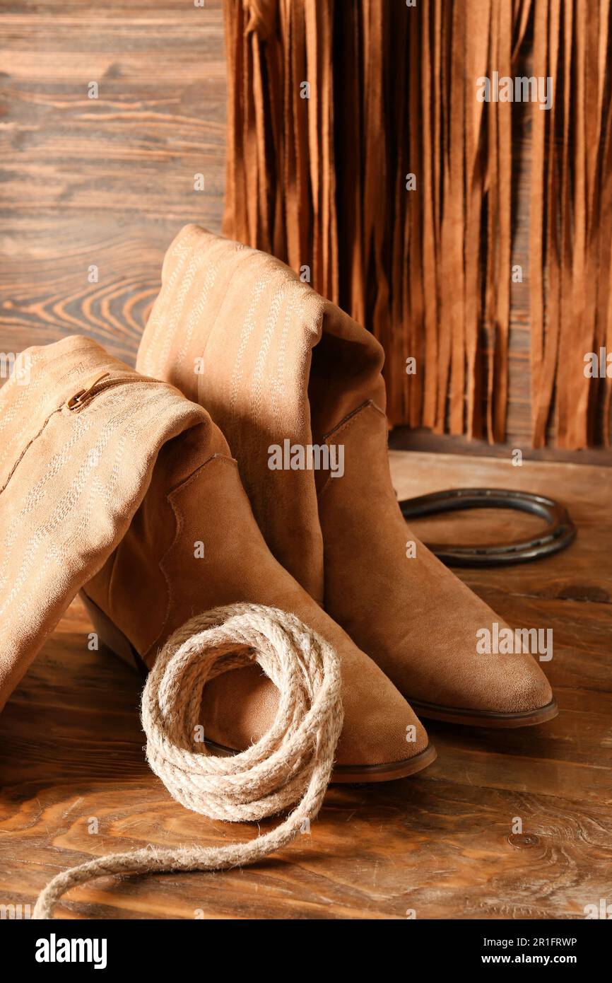 Cowboy boots, lasso and horseshoe on wooden background Stock Photo - Alamy
