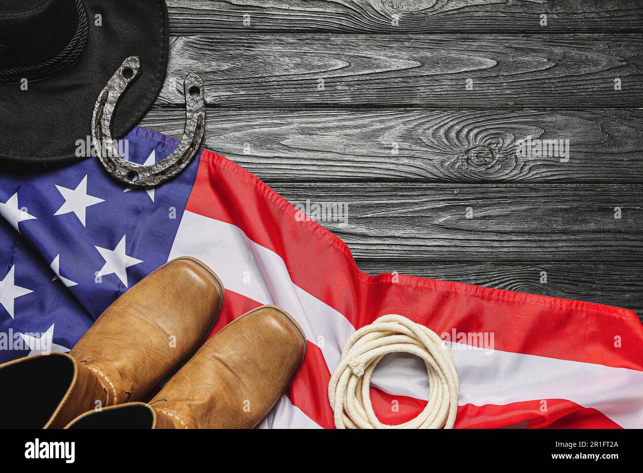 Composition with different cowboy accessories and flag of USA on black ...