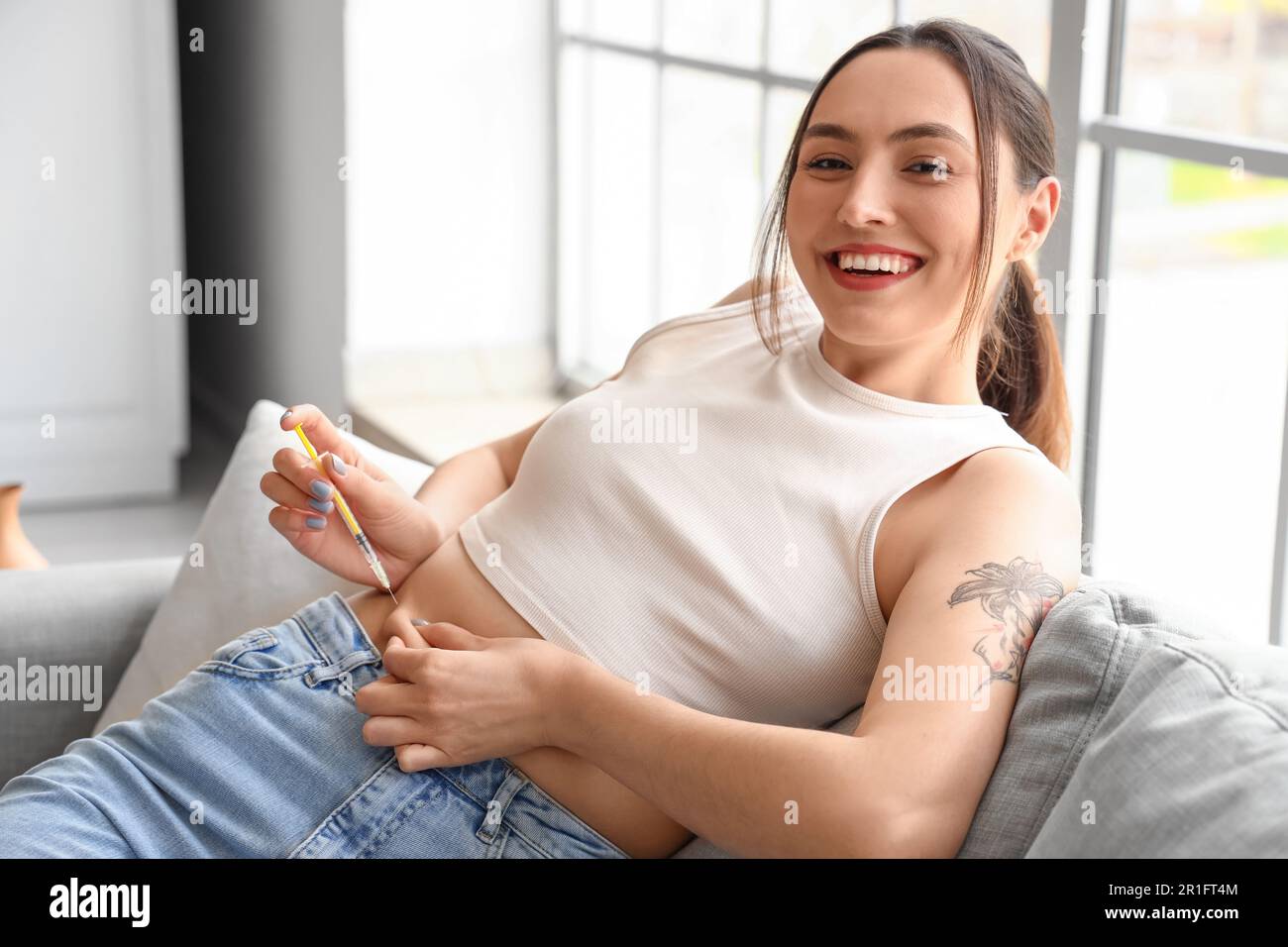 Young diabetic woman giving herself insulin injection at home Stock ...