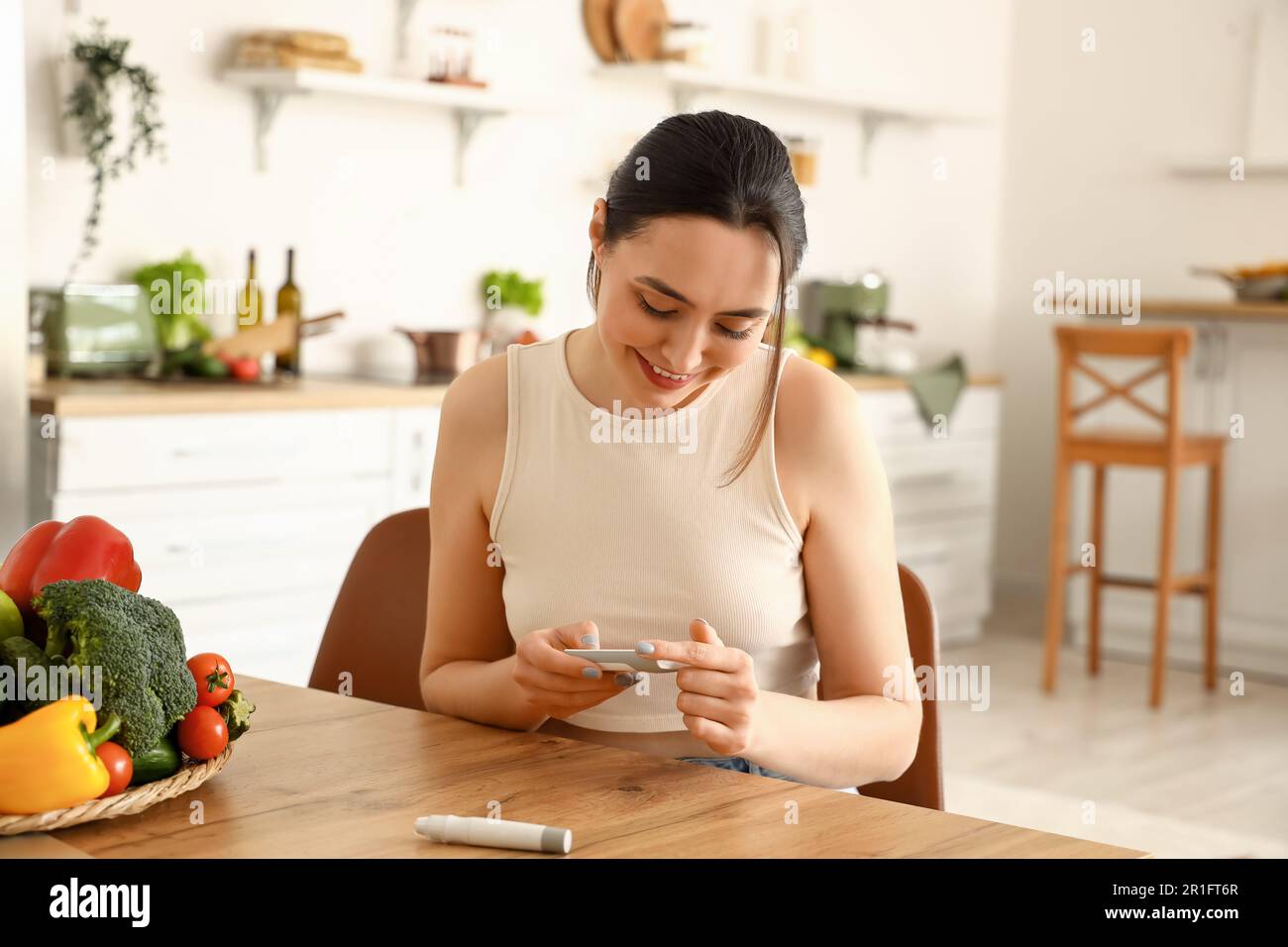 Young diabetic woman using glucometer at home Stock Photo - Alamy