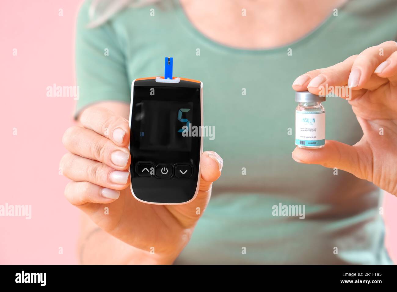 Mature diabetic woman with glucometer and insulin on pink background ...