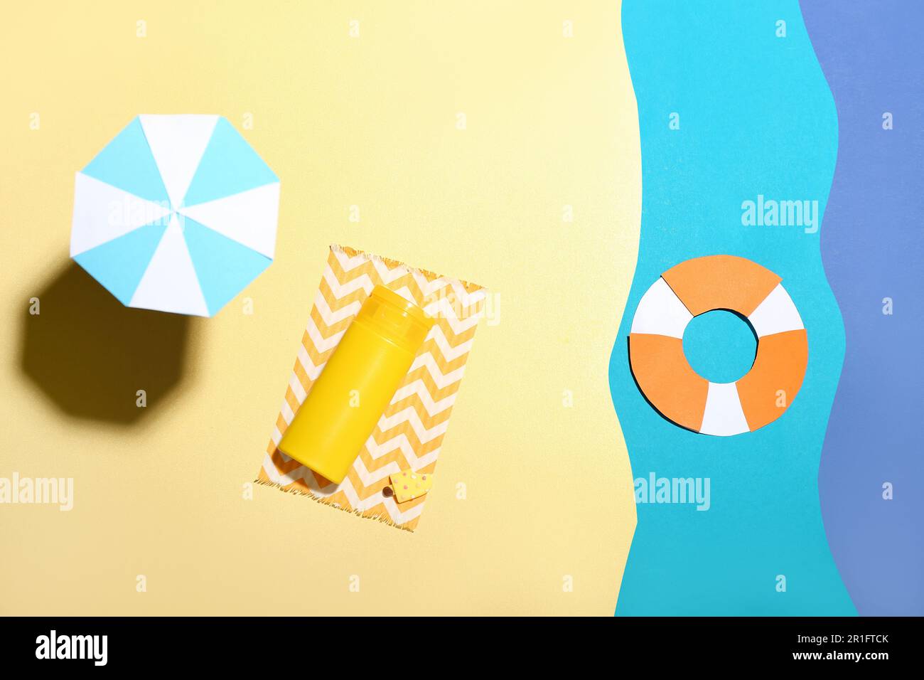 Creative composition with miniature umbrella and sunscreen on beach ...