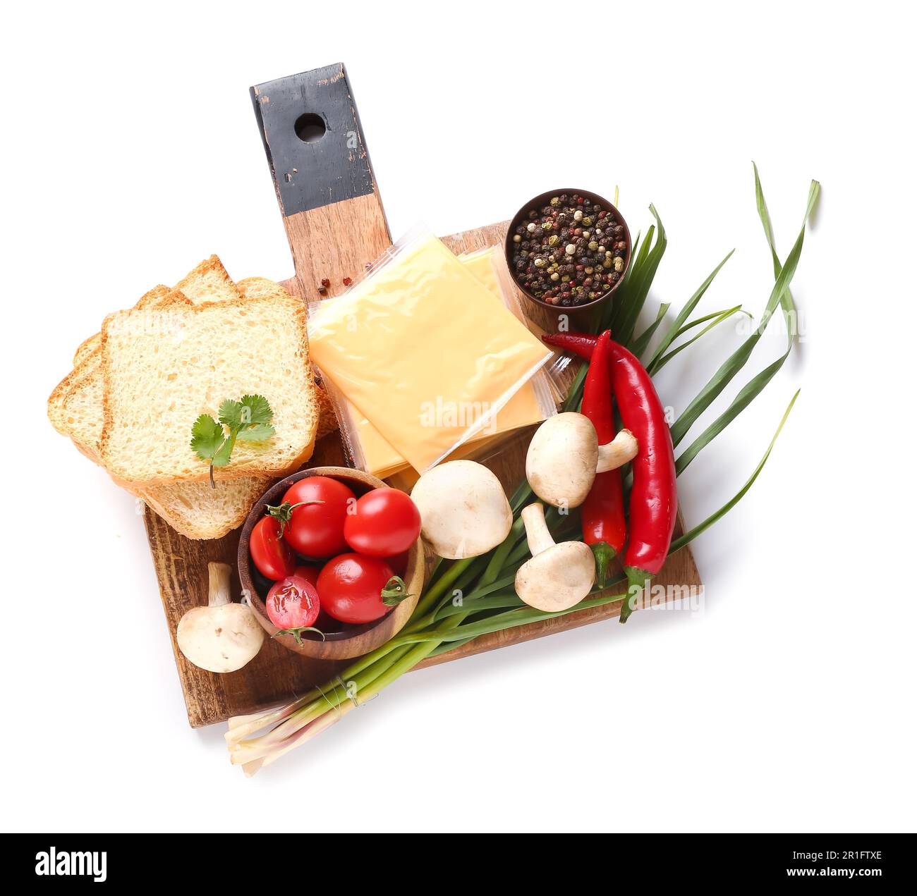 Board of tasty processed cheese with vegetables and bread on white ...