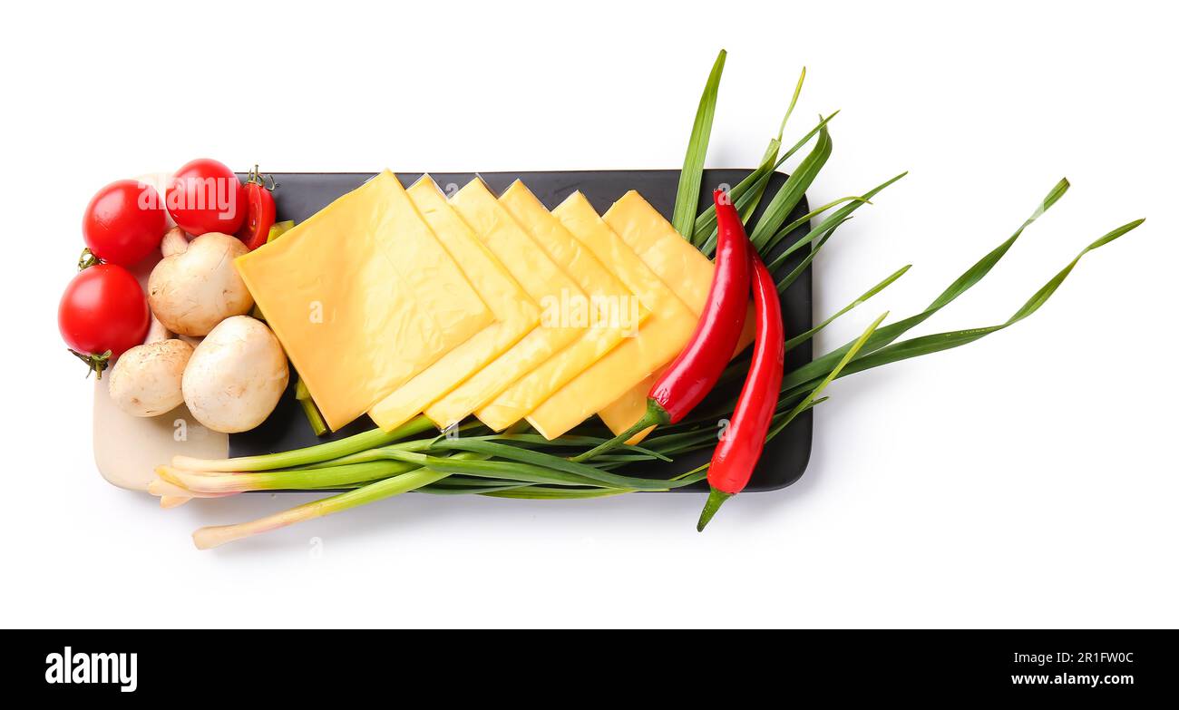 Board of tasty processed cheese with vegetables on white background ...