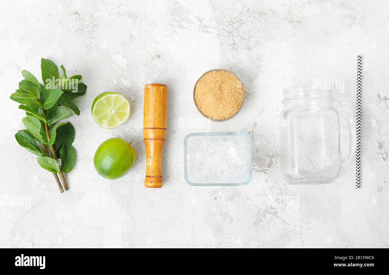 Mason jar, mortar and ingredients for preparing mojito on light ...