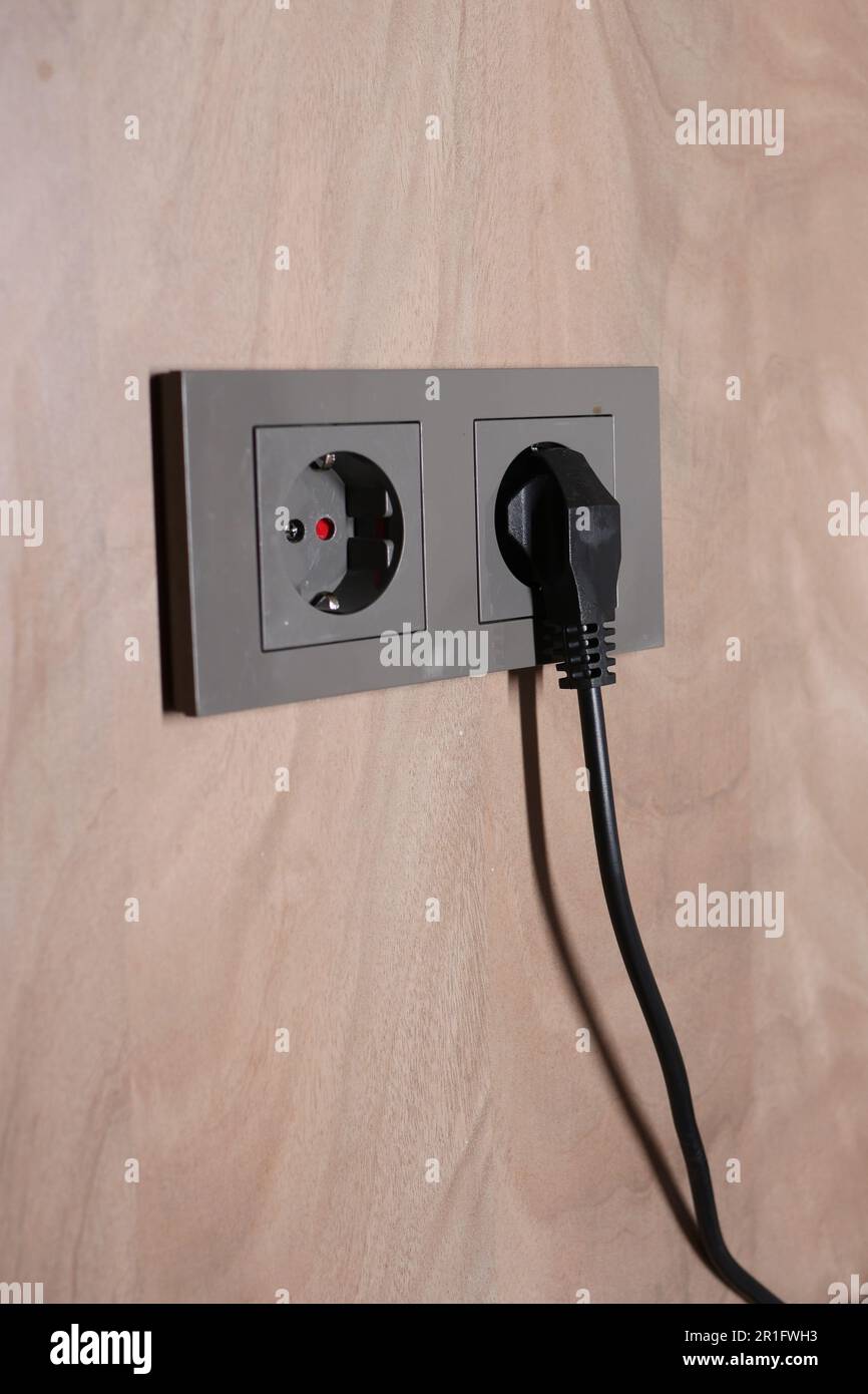 white color power cord cable plugged into wall Stock Photo - Alamy