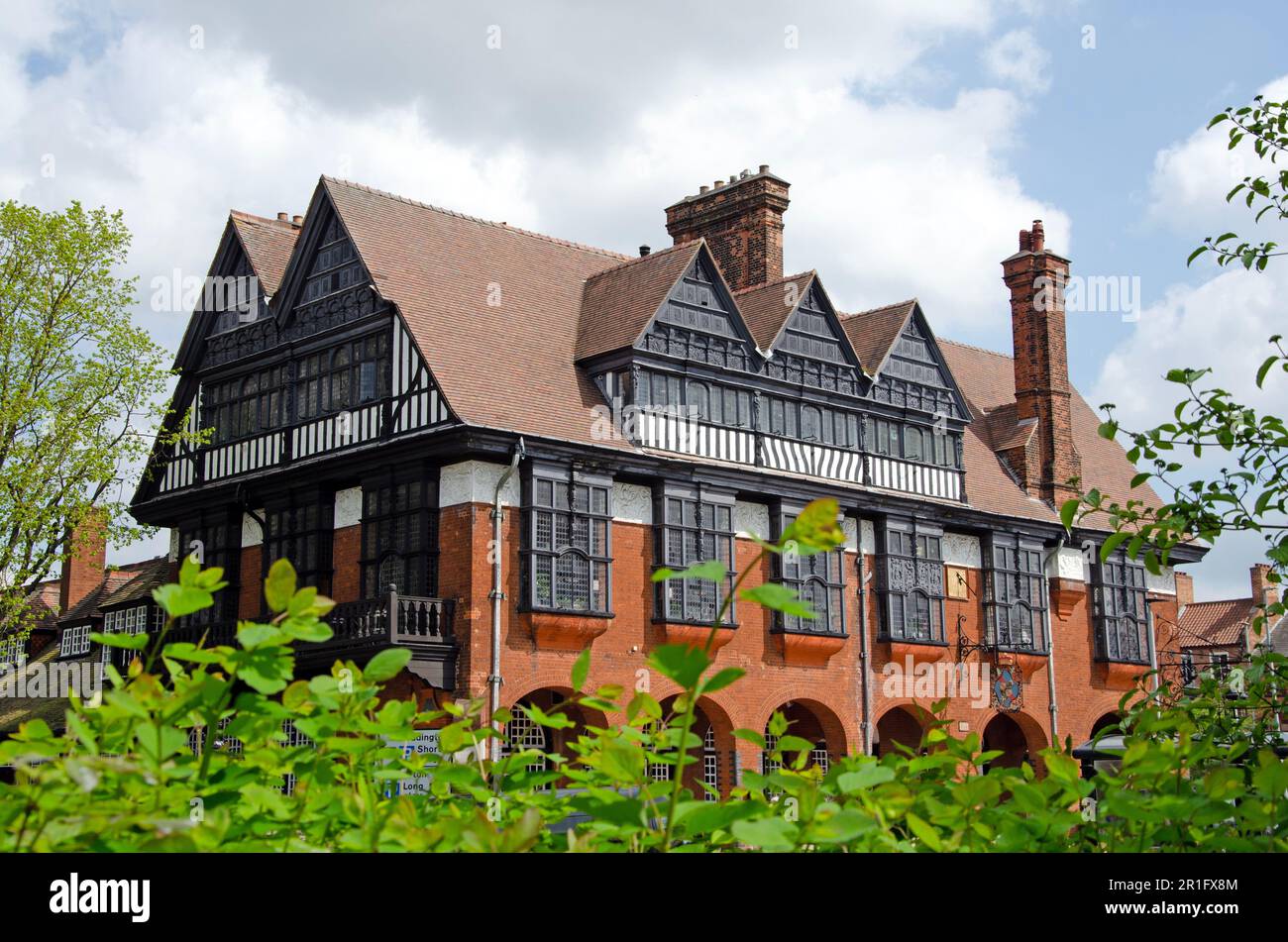 Large tudor style house in Newark-on-Trent on a spring day and bushes ...