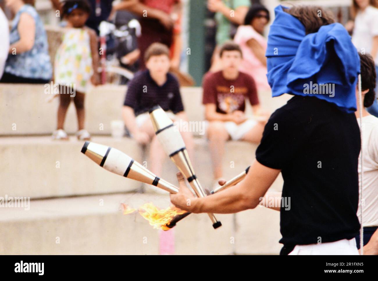 A performer juggling fire in front of a crowd at Harborplace in ...