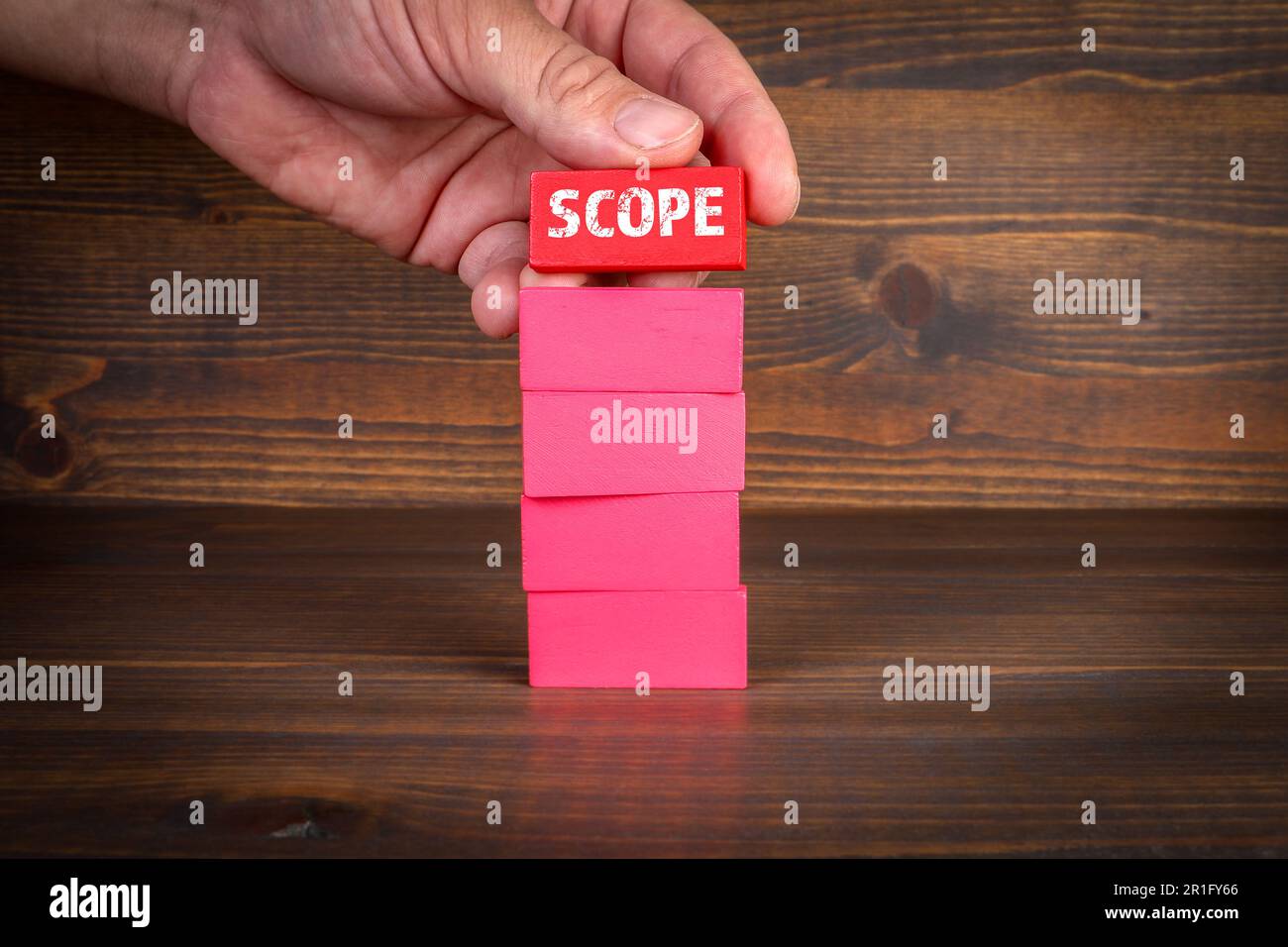 Scope Concept. Red blocks in a pile on a wooden texture background ...