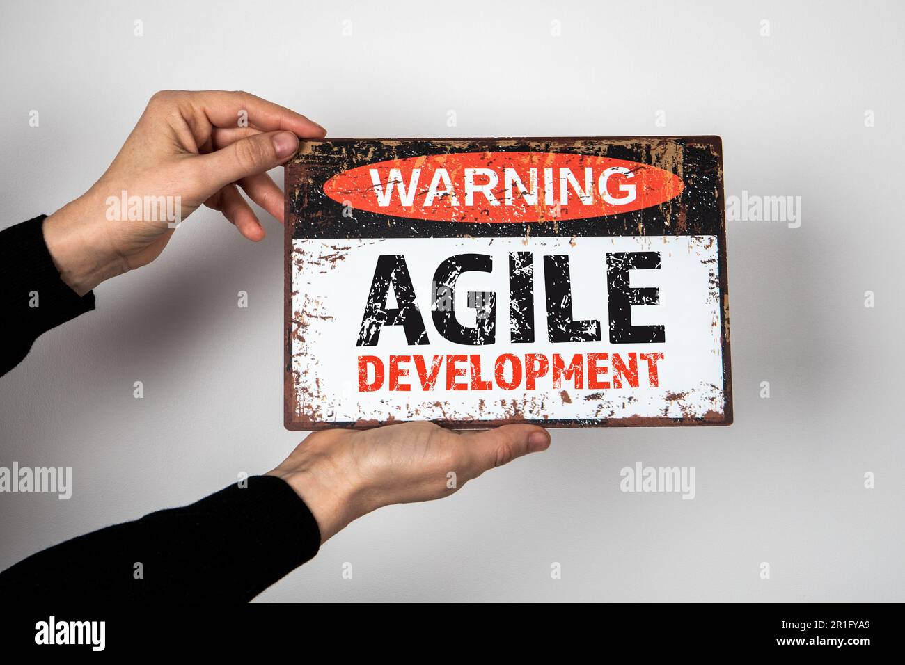 AGILE DEVELOPMENT. Warning sign with text in the hands of a woman Stock ...