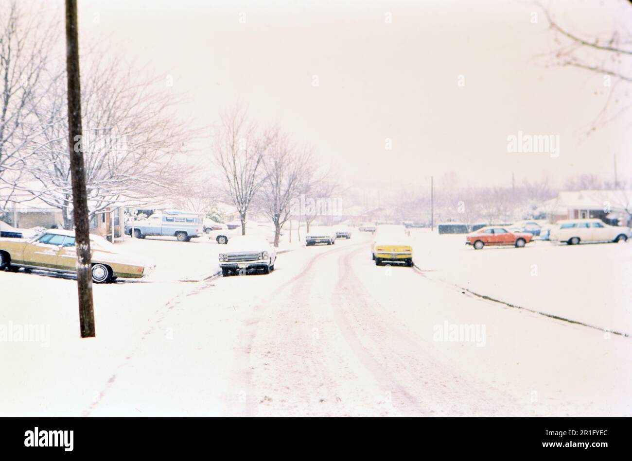 Cars parked in street and in driveways during a winter storm ca. 1977 ...