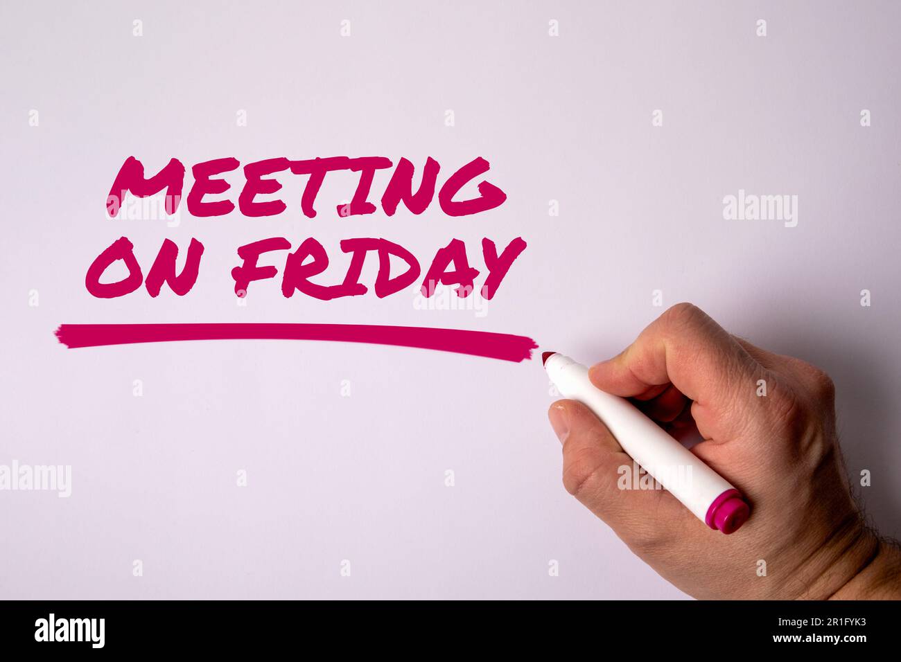 Meeting on Friday. Handwriting text with marker on a white background ...