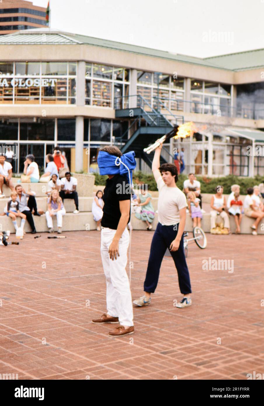 A performer juggling fire in front of a crowd at Harborplace in ...