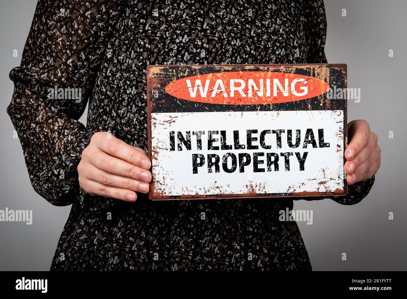Intellectual Property. Warning sign with text in the hands of a woman ...