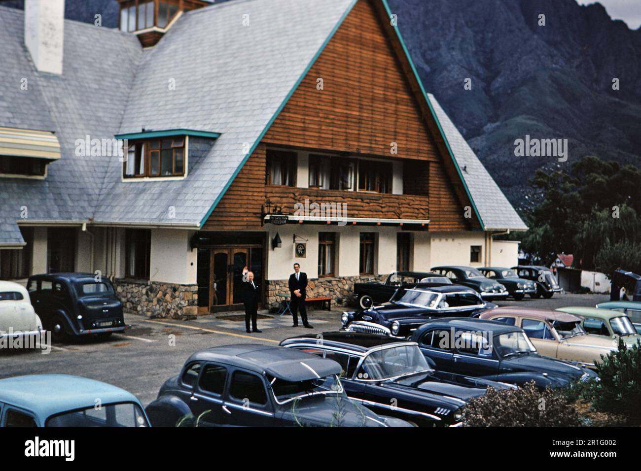Well dressed men, luxury cars, in the parking lot of the Swiss Farm ...