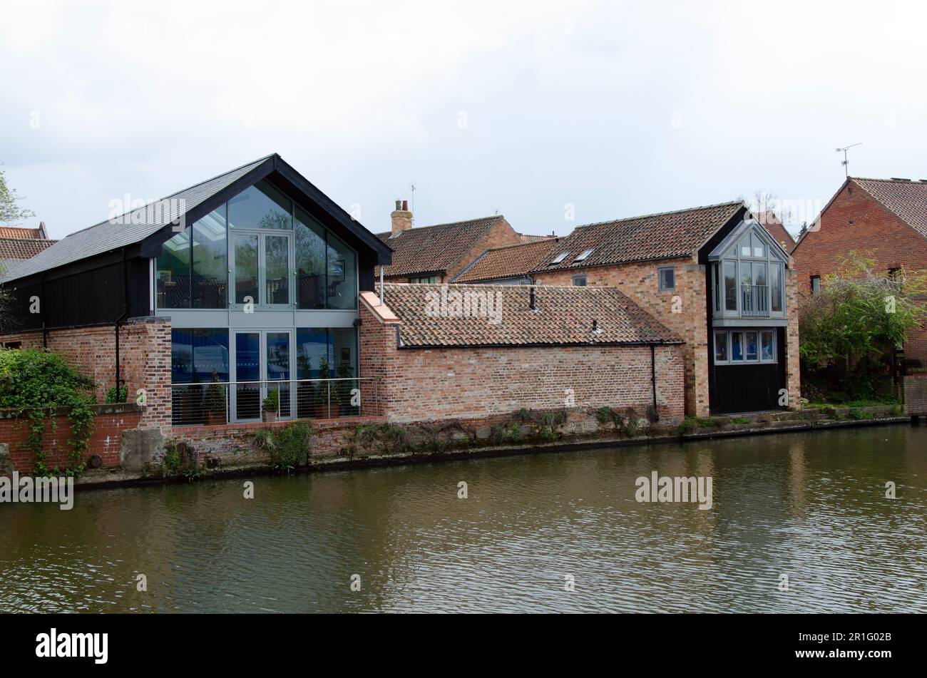 Modern buildings among old on river front. River Trent Newark. Glass ...