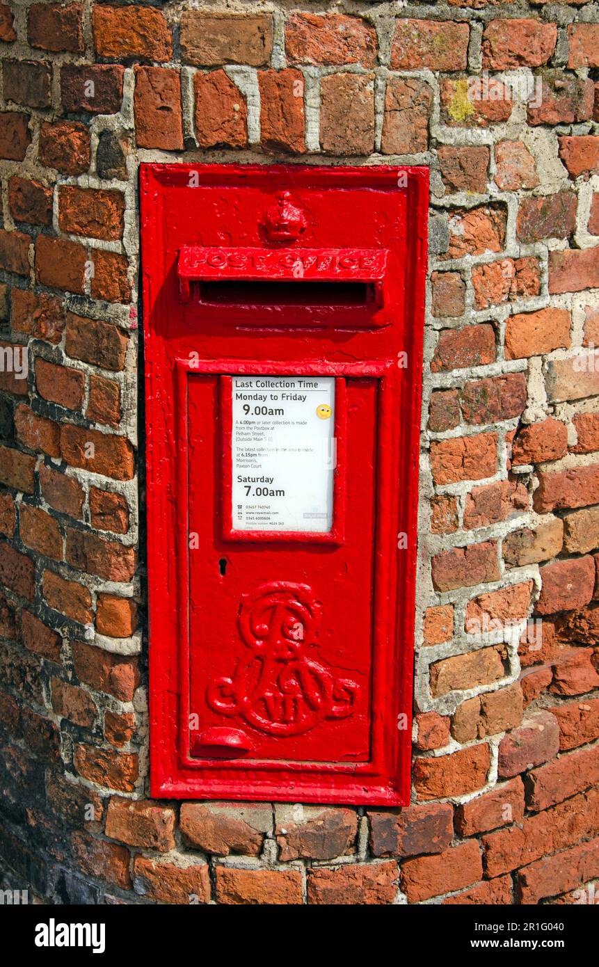 Edward VII red post box in old brick wall. Cypher of old red post box ...