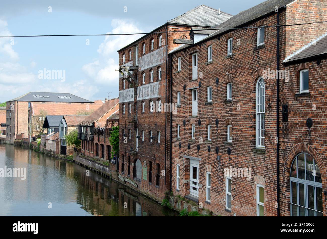 Old brick warehouses converted into lofts along a river on a sunny ...