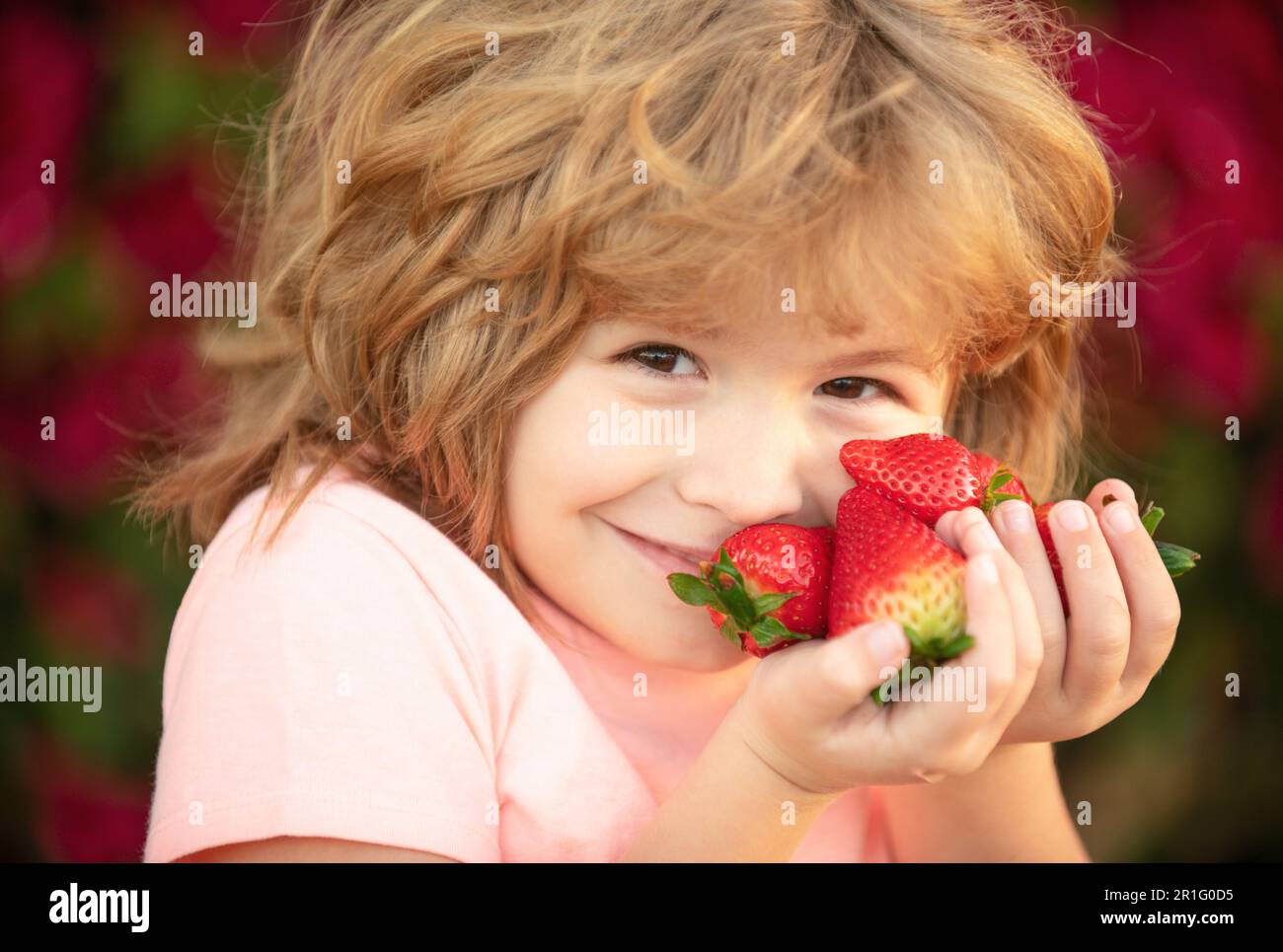 Healthy kids food. Adorable kid eating strawberry Stock Photo - Alamy