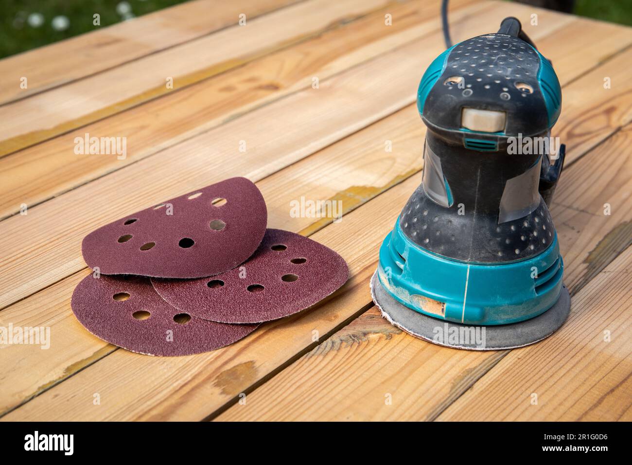 Round sandpaper discs and orbital sander. Wooden background Stock Photo ...