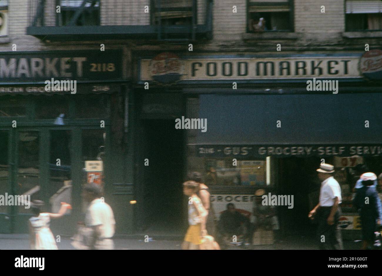 New Yorkers walking by Gus' Grocery (food market) in New York City ca ...