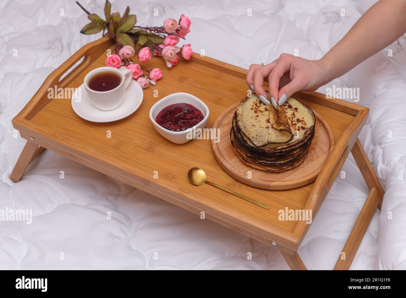 delicious pancakes on the breakfast table in bed. a pancake in women's ...