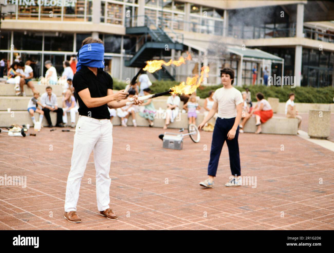 A performer juggling fire in front of a crowd at Harborplace in ...