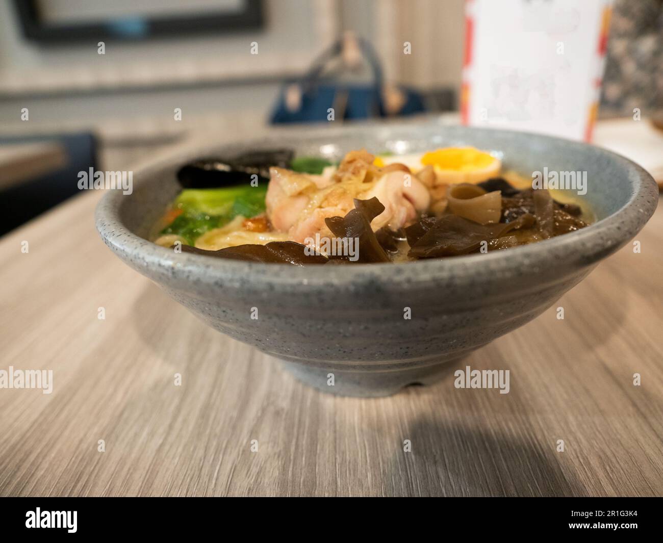 Side view of a bowl of ramen on a wooden table Stock Photo - Alamy